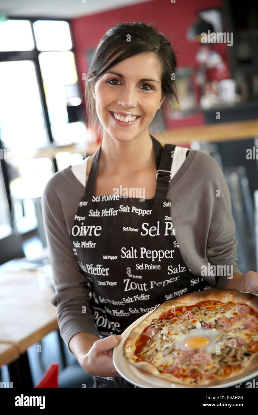 Beautiful waitress serving pizza to customers Stock Photo - Alamy