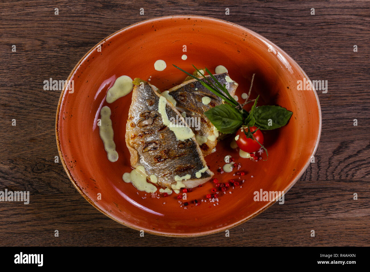 Grilled dorada fillet served tomato and onion Stock Photo - Alamy