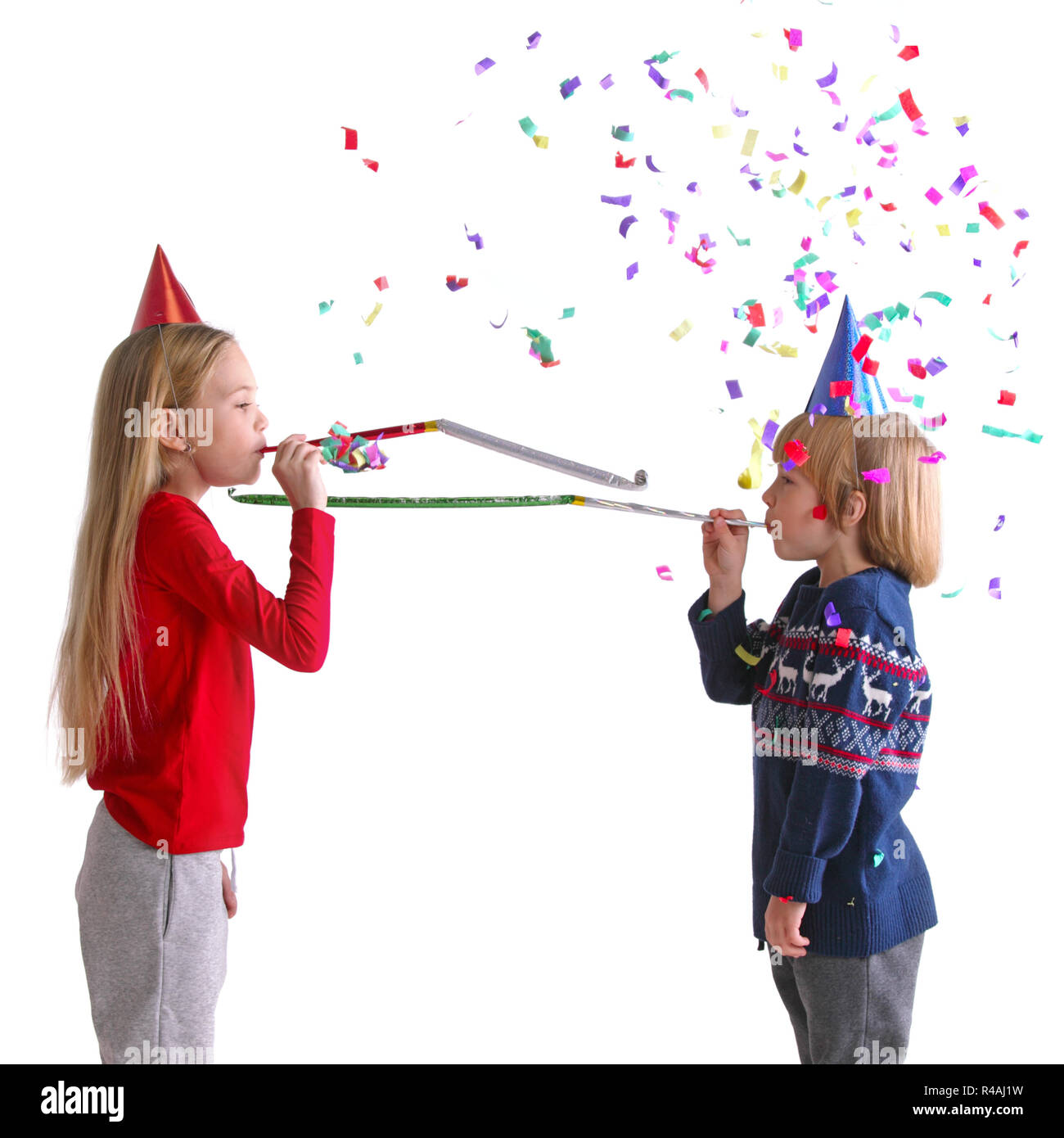 Children blowing party trumpets with confetti celebrating new year ...