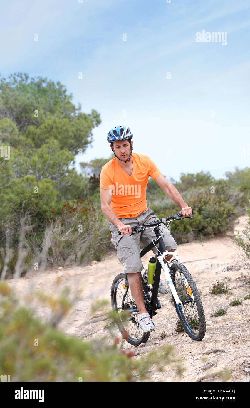 Man riding mountain bike on island trail Stock Photo - Alamy