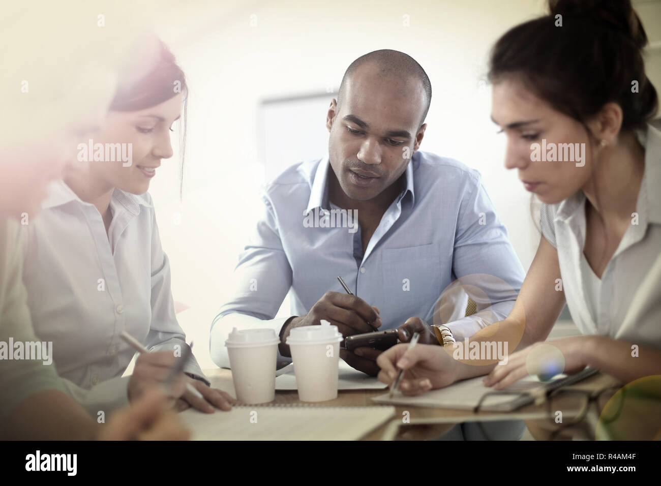Young business people meeting around table Stock Photo - Alamy