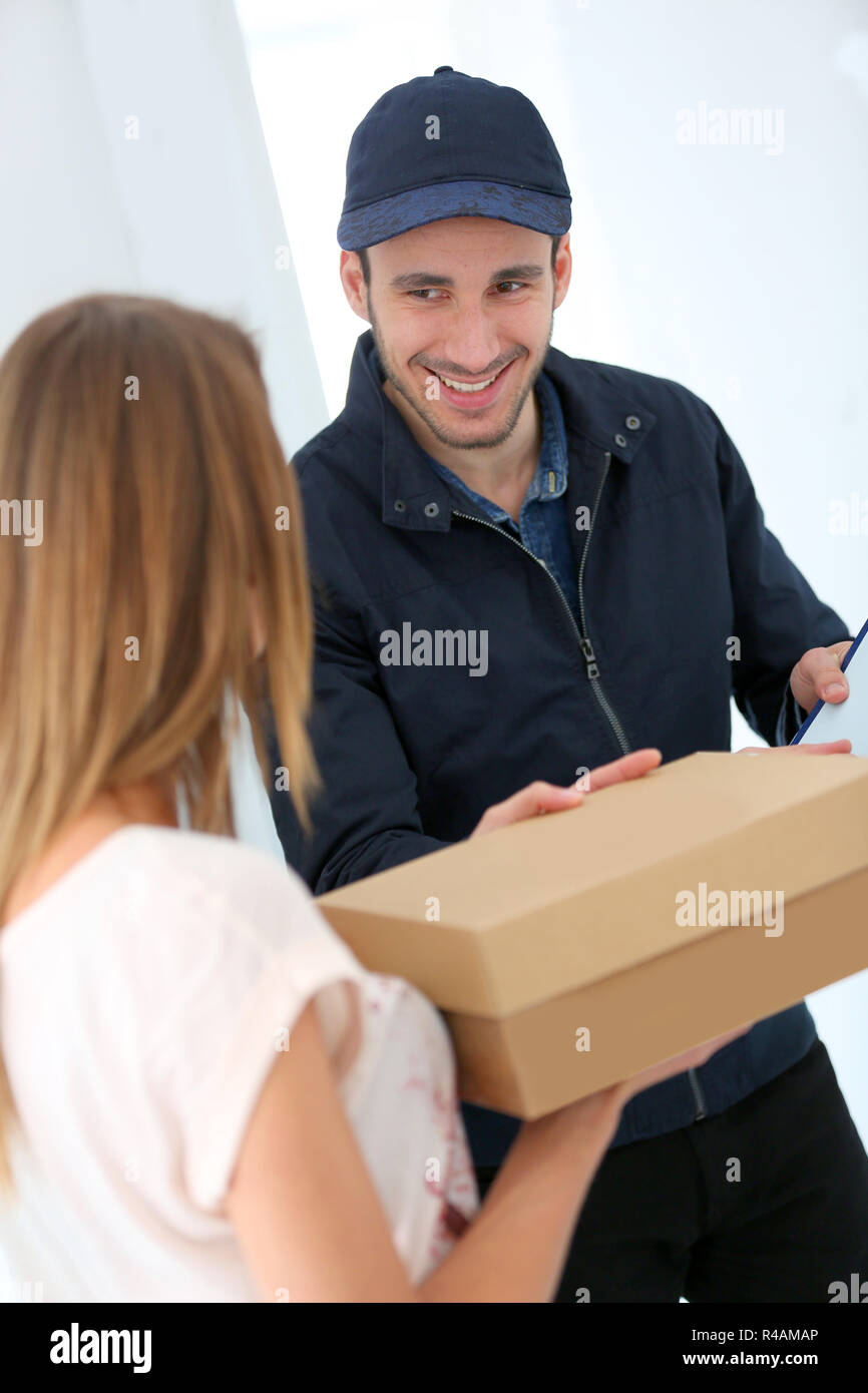Smiling delivery man giving cardbox to customer Stock Photo - Alamy