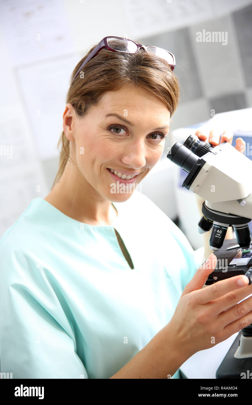 Doctor in laboratory looking through microscope Stock Photo - Alamy