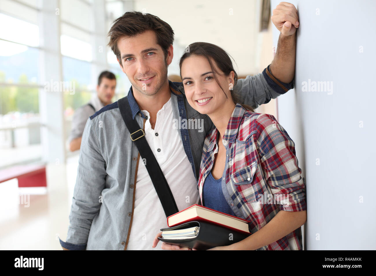 Friends standing in university hallway Stock Photo - Alamy