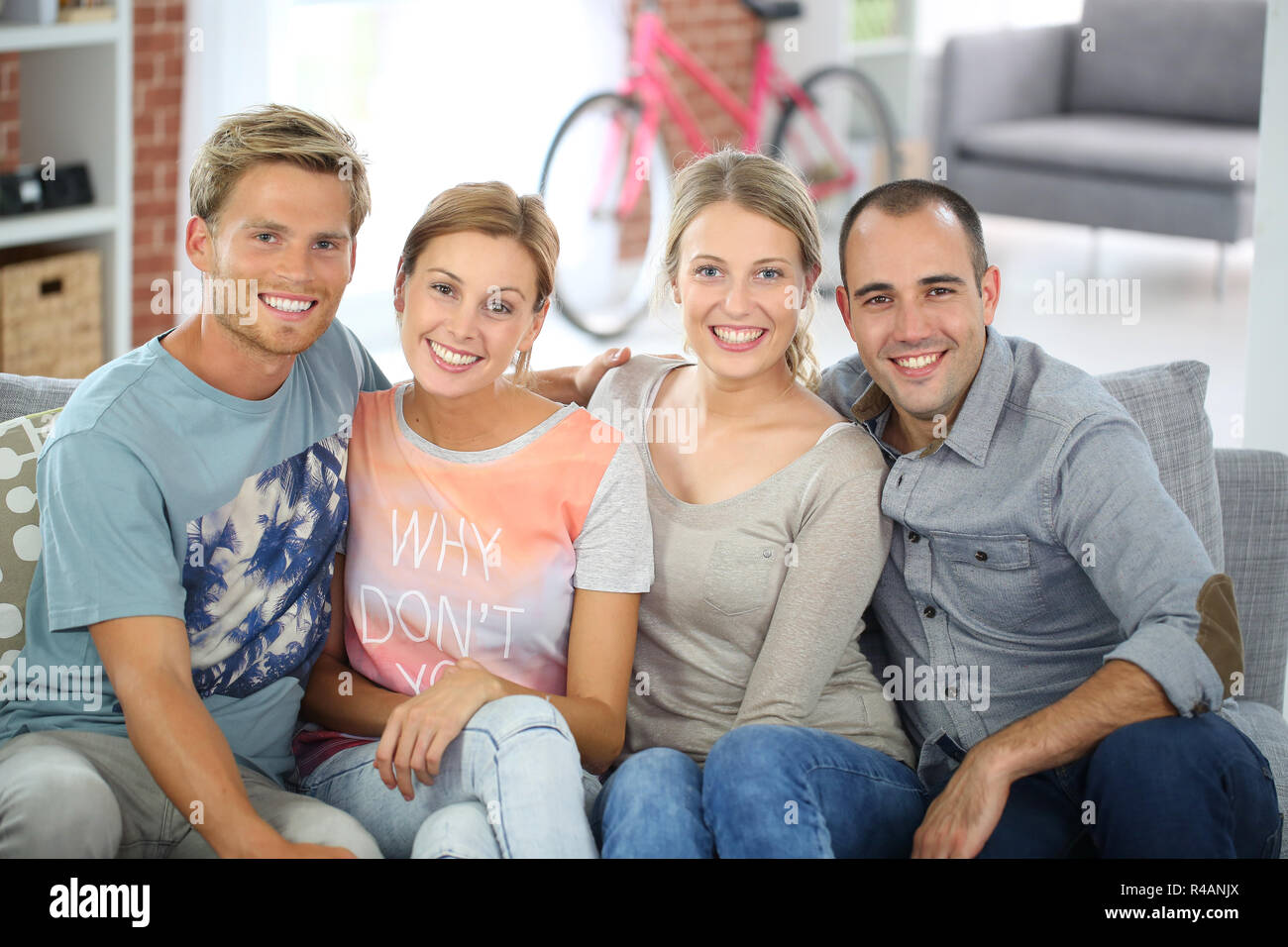 Roommates sitting together in couch Stock Photo - Alamy
