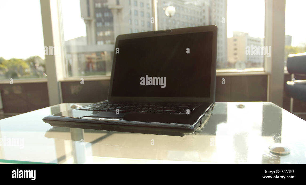 open laptop on glass table in modern office Stock Photo - Alamy