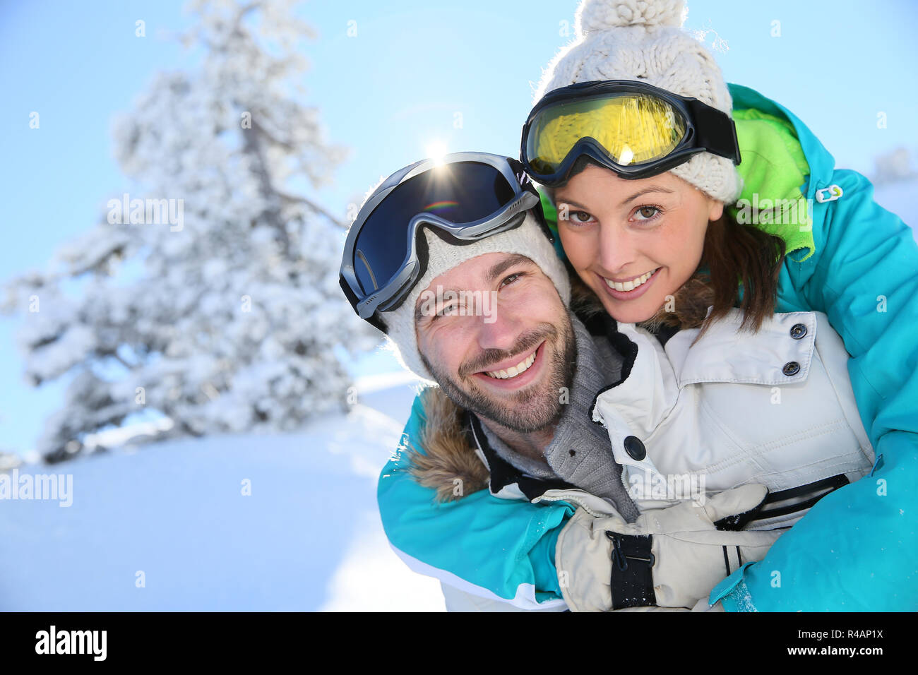 Man giving girlfriend piggyback ride in the snowy mountain Stock Photo ...
