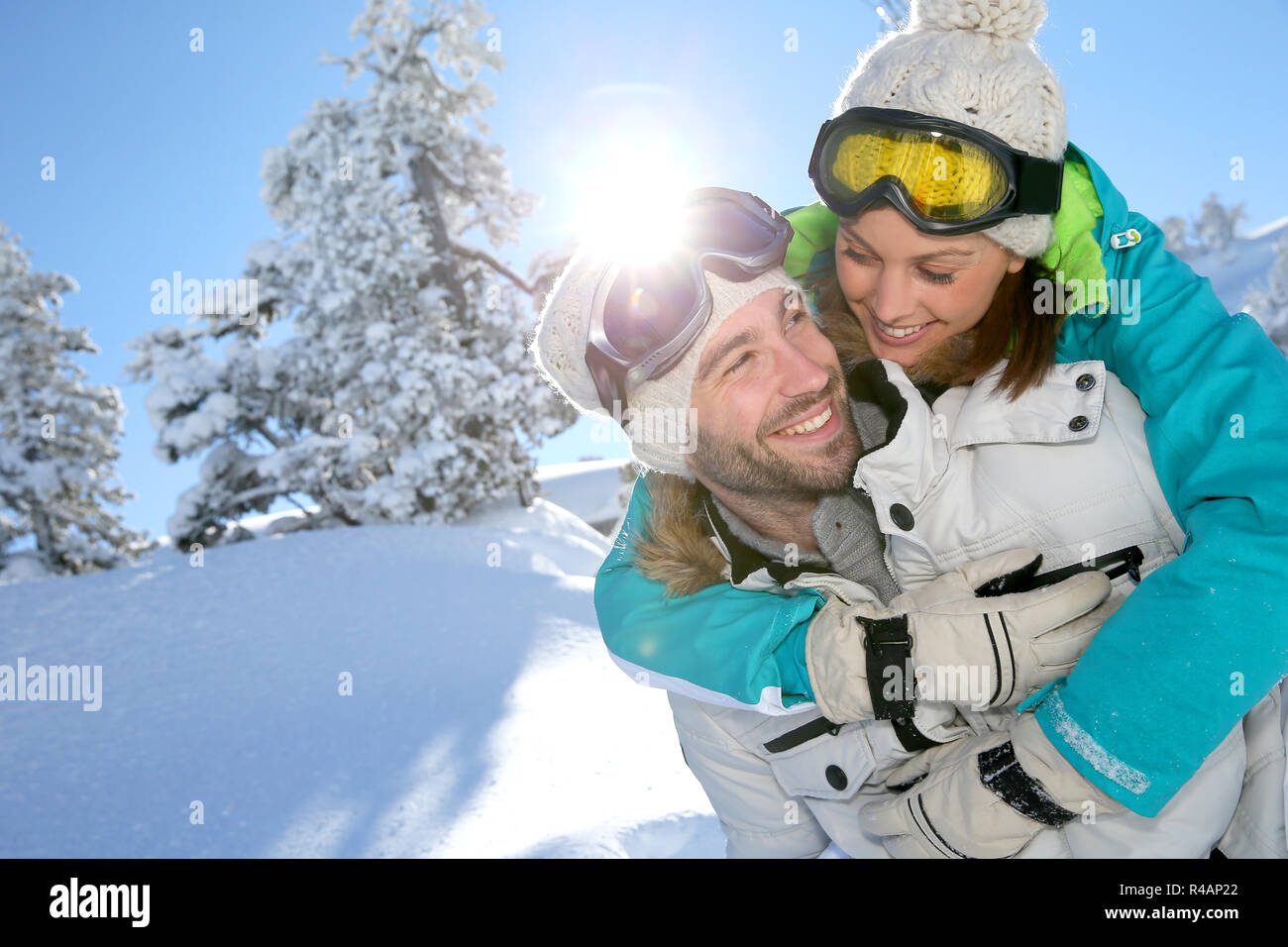 Man giving girlfriend piggyback ride in the snowy mountain Stock Photo ...