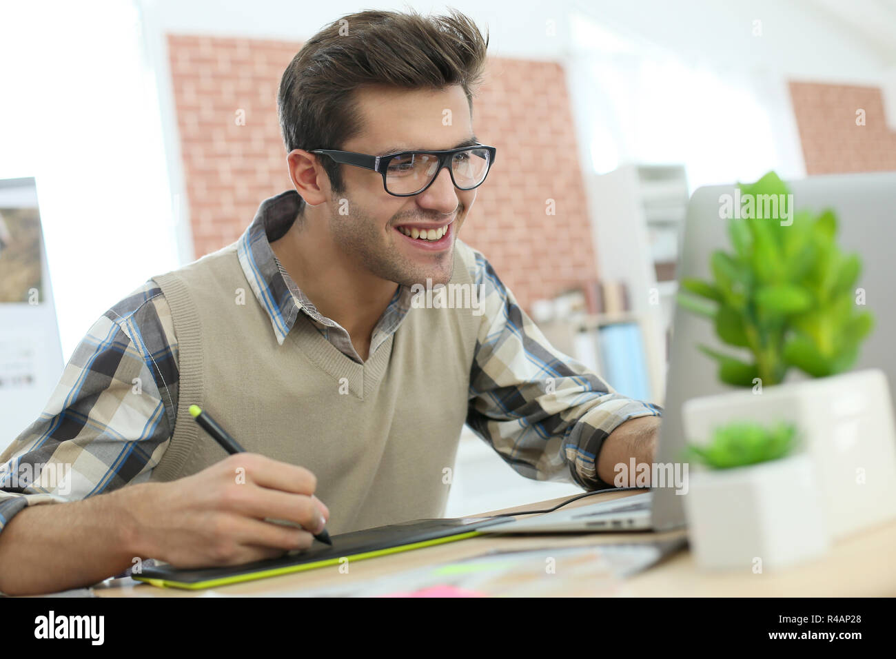 Young man in office using graphic tablet Stock Photo - Alamy