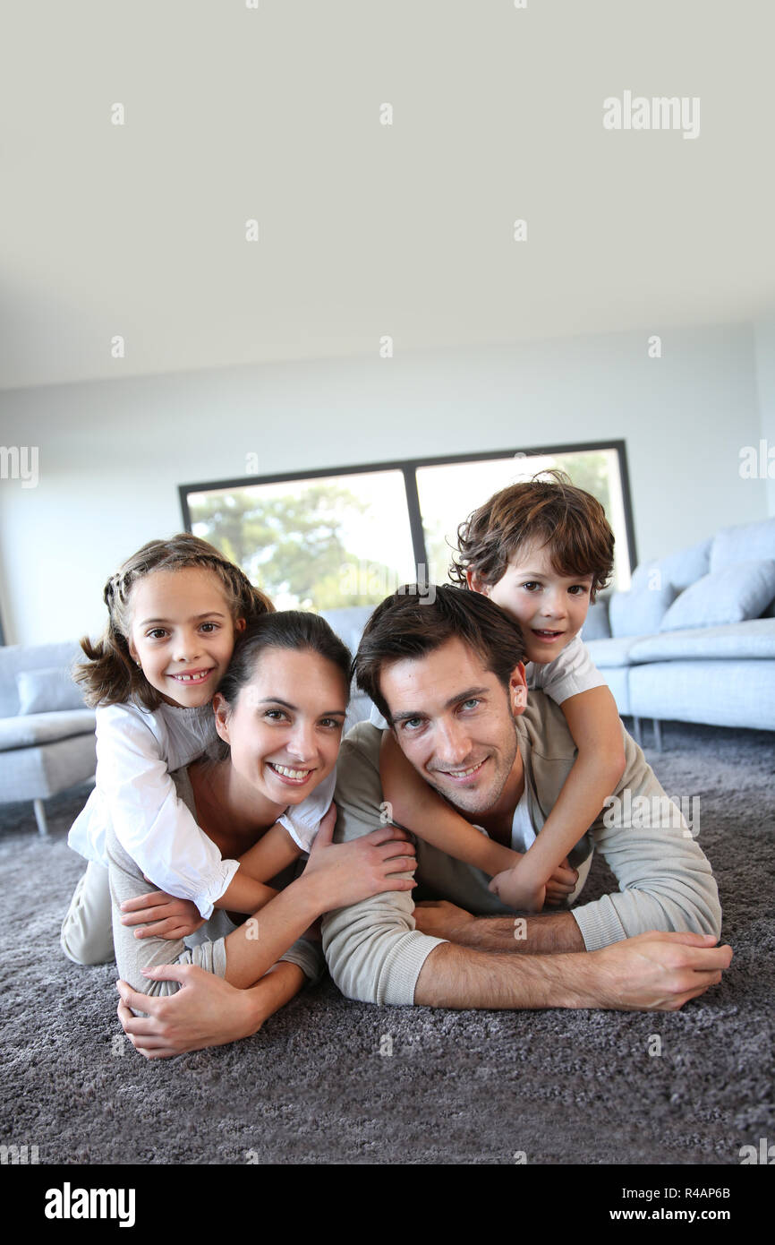 Family at home relaxing on carpet Stock Photo - Alamy