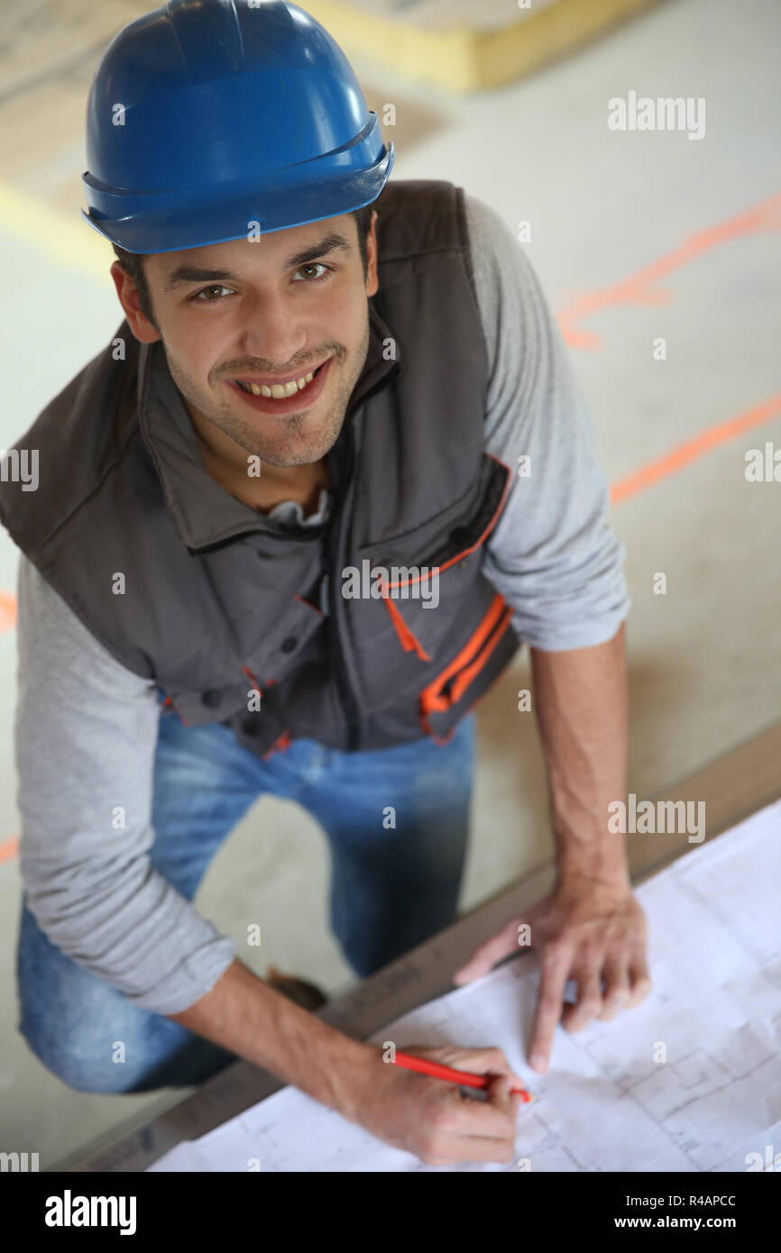 Construction worker checking blueprint Stock Photo - Alamy