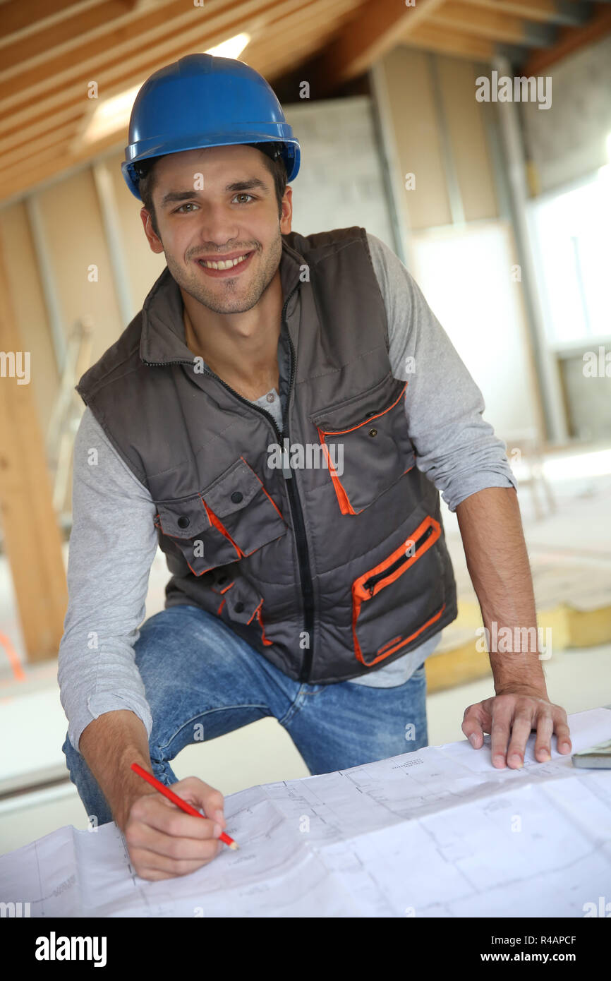 Construction worker checking blueprint Stock Photo - Alamy