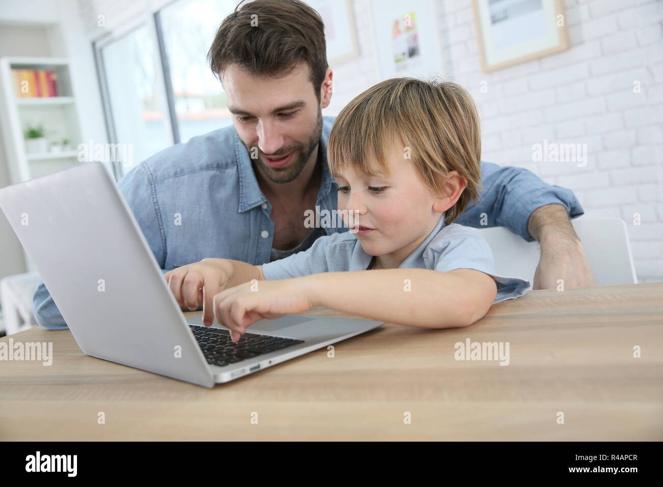 Daddy and son playing on laptop computer Stock Photo - Alamy