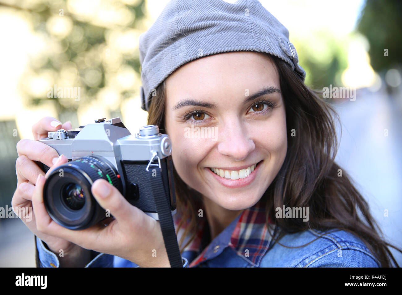 Portrait of trendy girl holding camera Stock Photo - Alamy