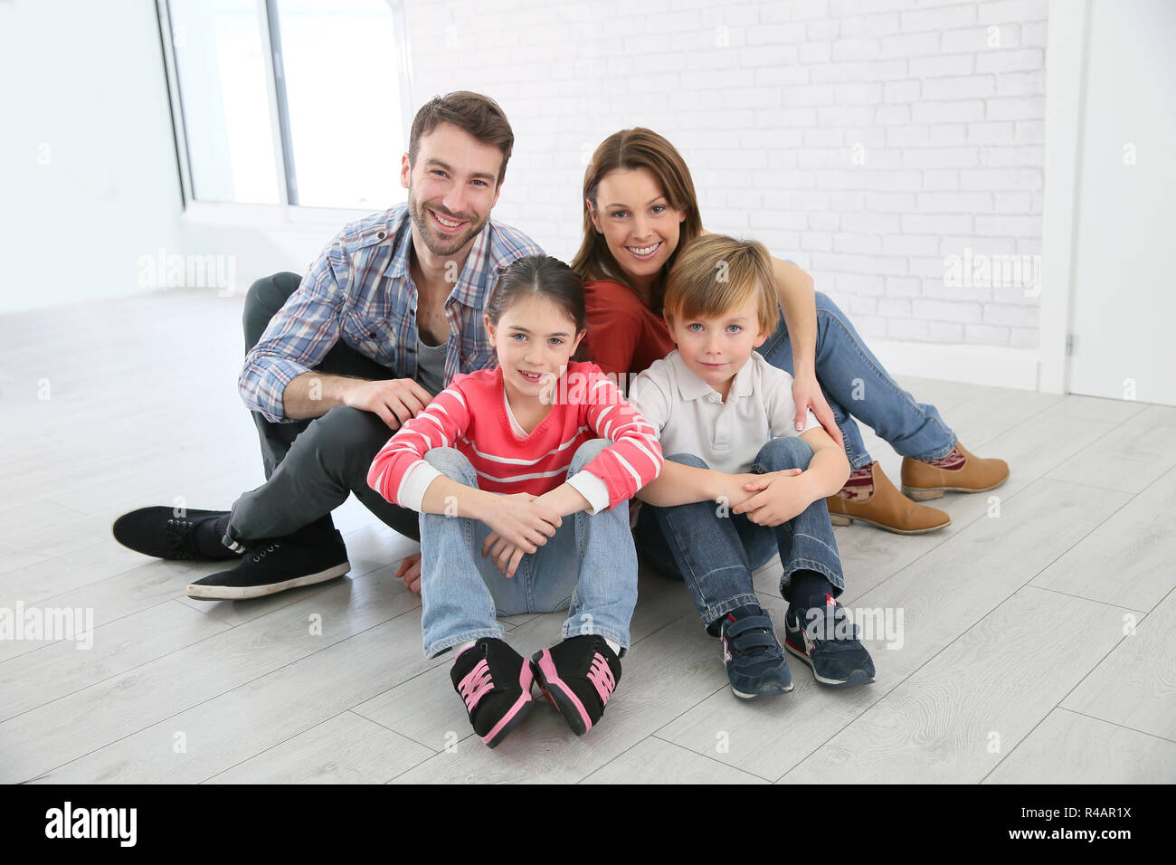 Family of four sitting on the floor Stock Photo - Alamy