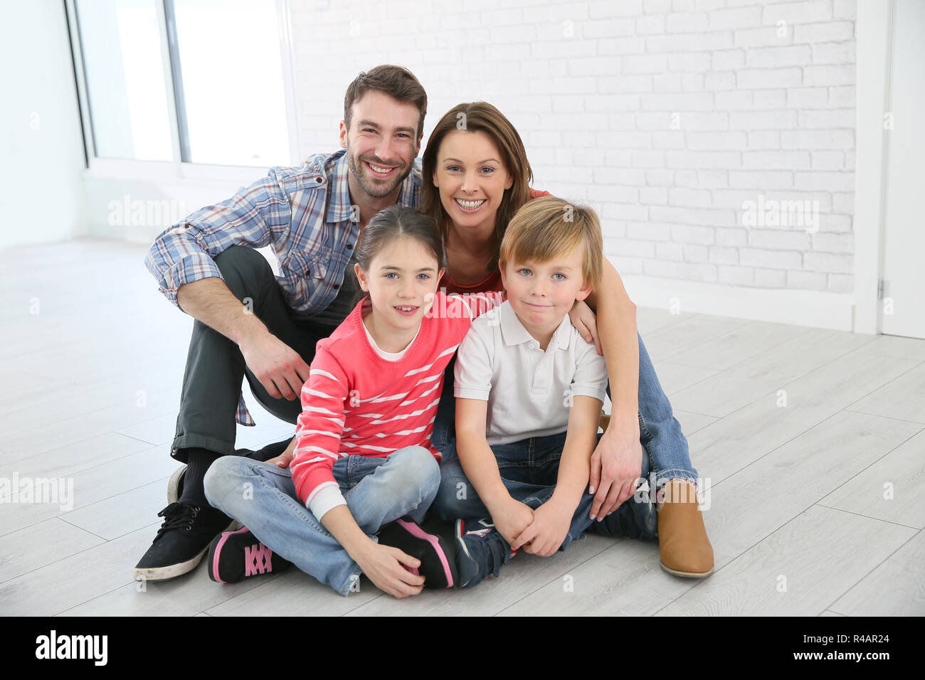 Family of four sitting on the floor Stock Photo - Alamy