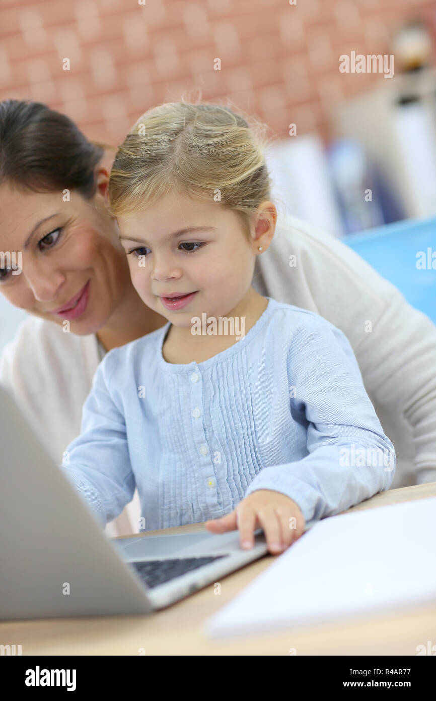 Mother and little girl using laptop computer Stock Photo - Alamy