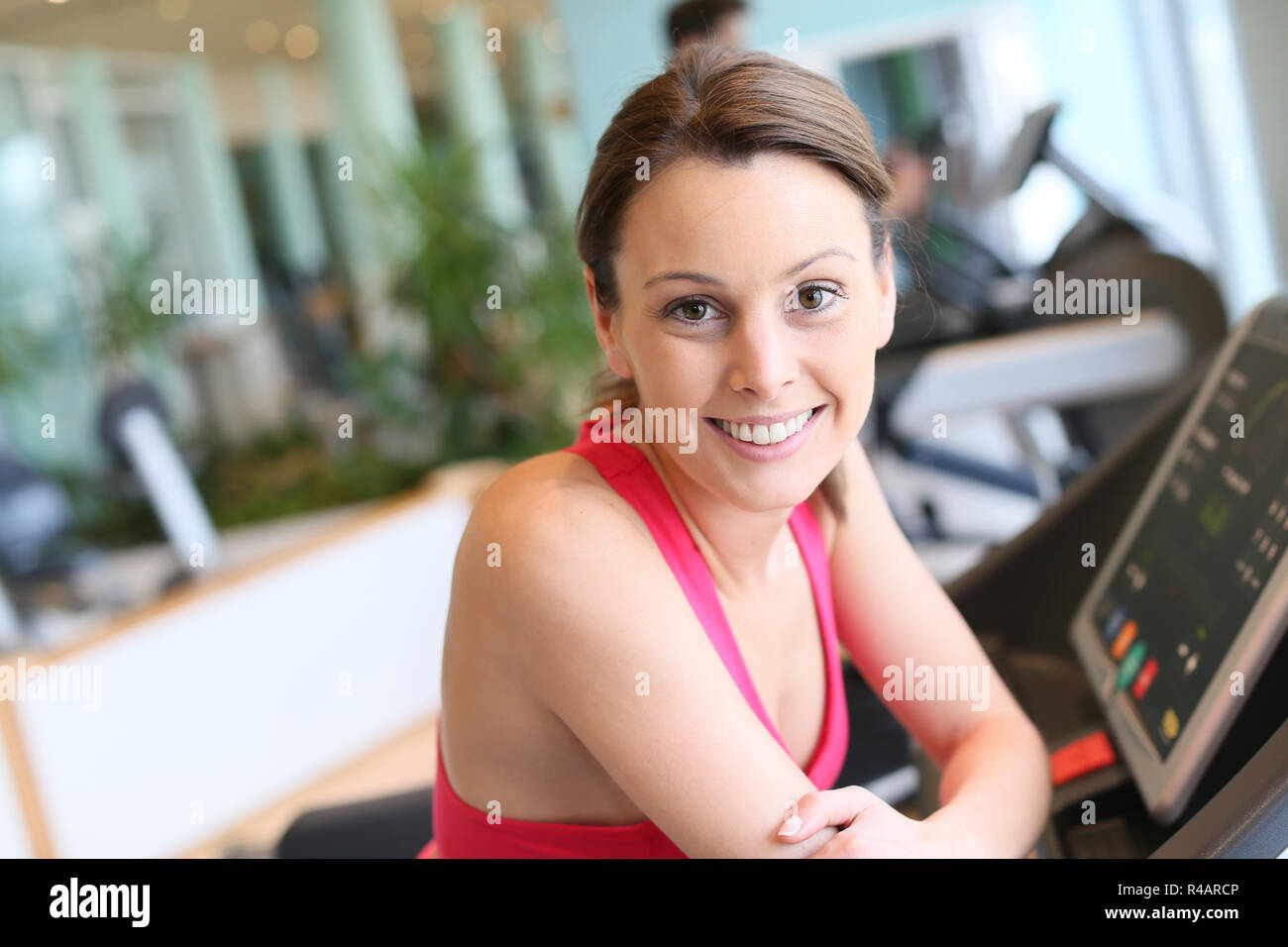Portrait of smiling fitness girl leaning on treadmill Stock Photo - Alamy