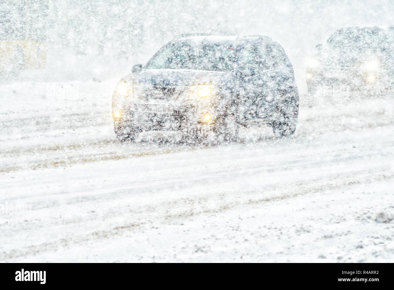Car rides through a snowstorm. Limited vision on the road. Blizzard ...
