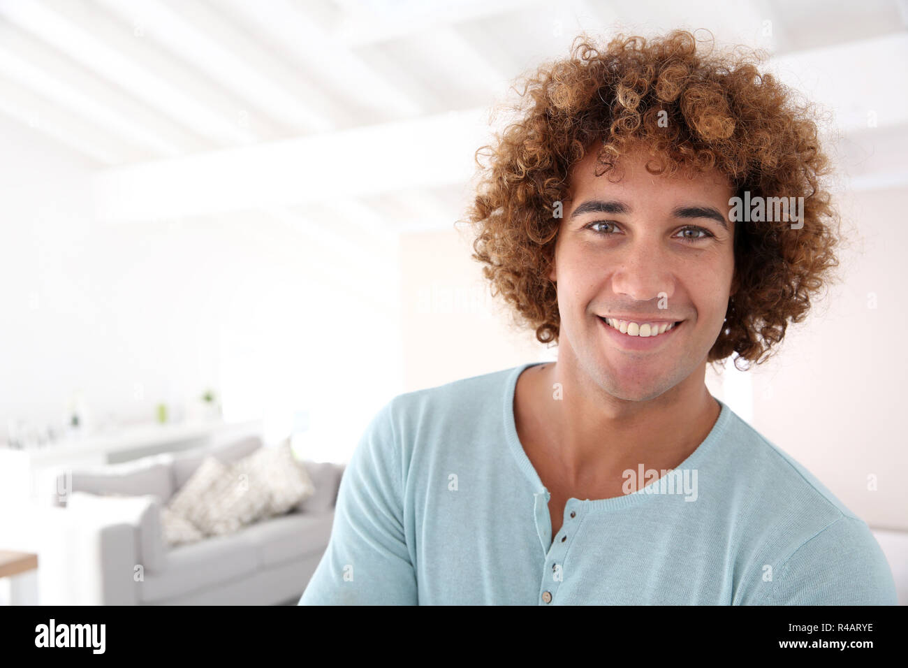 Handsome cheerful man standing in new home Stock Photo - Alamy
