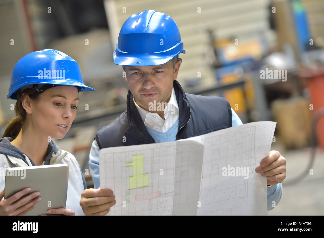 Engineers in mechanical factory reading instructions Stock Photo - Alamy