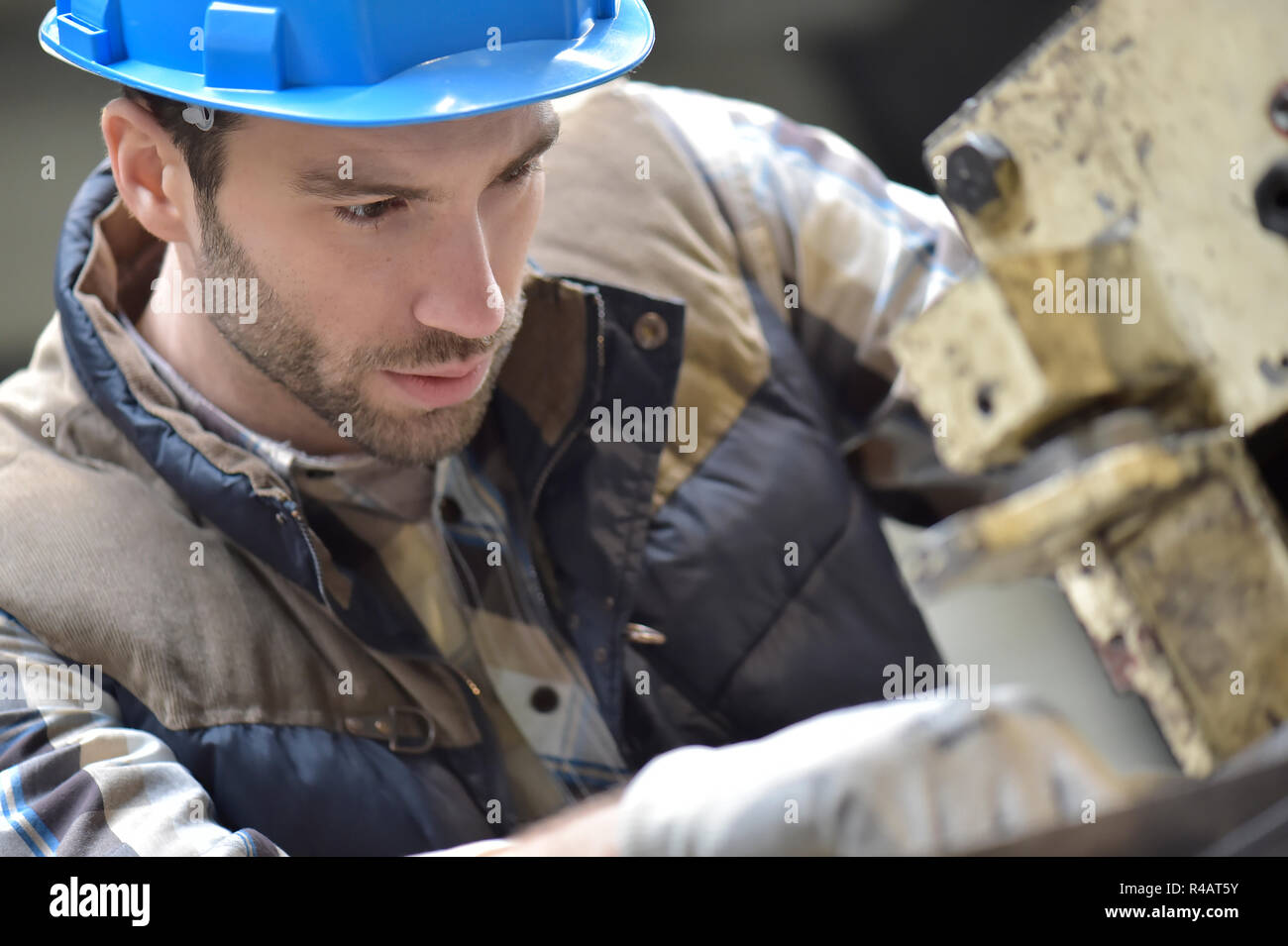 Industrial worker working on machine in factory Stock Photo - Alamy