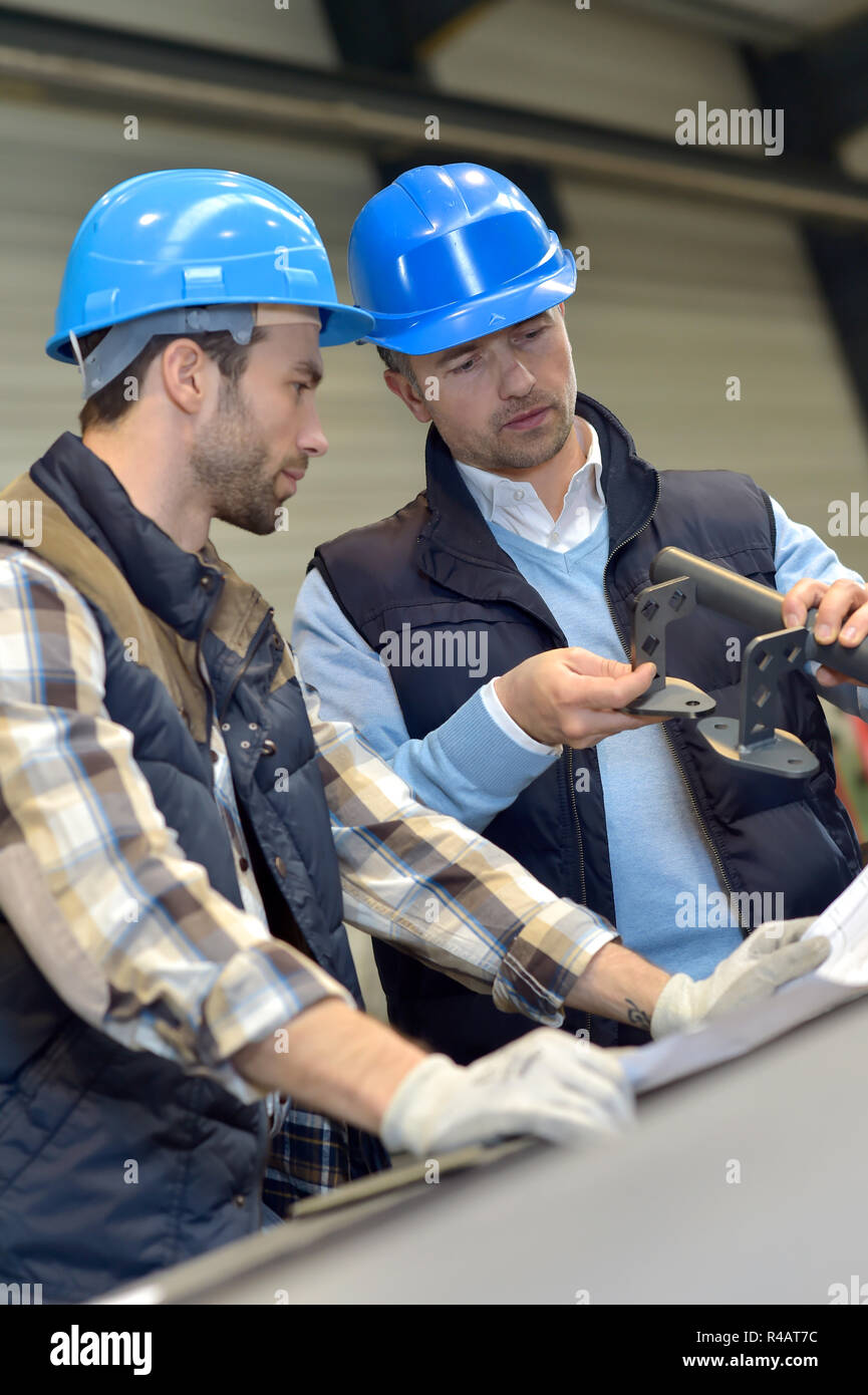 Engineer with mechanical worker checking on production Stock Photo - Alamy