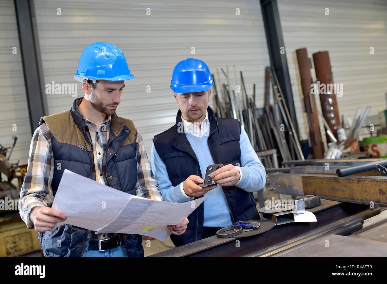 Engineer with mechanical worker checking on production Stock Photo - Alamy