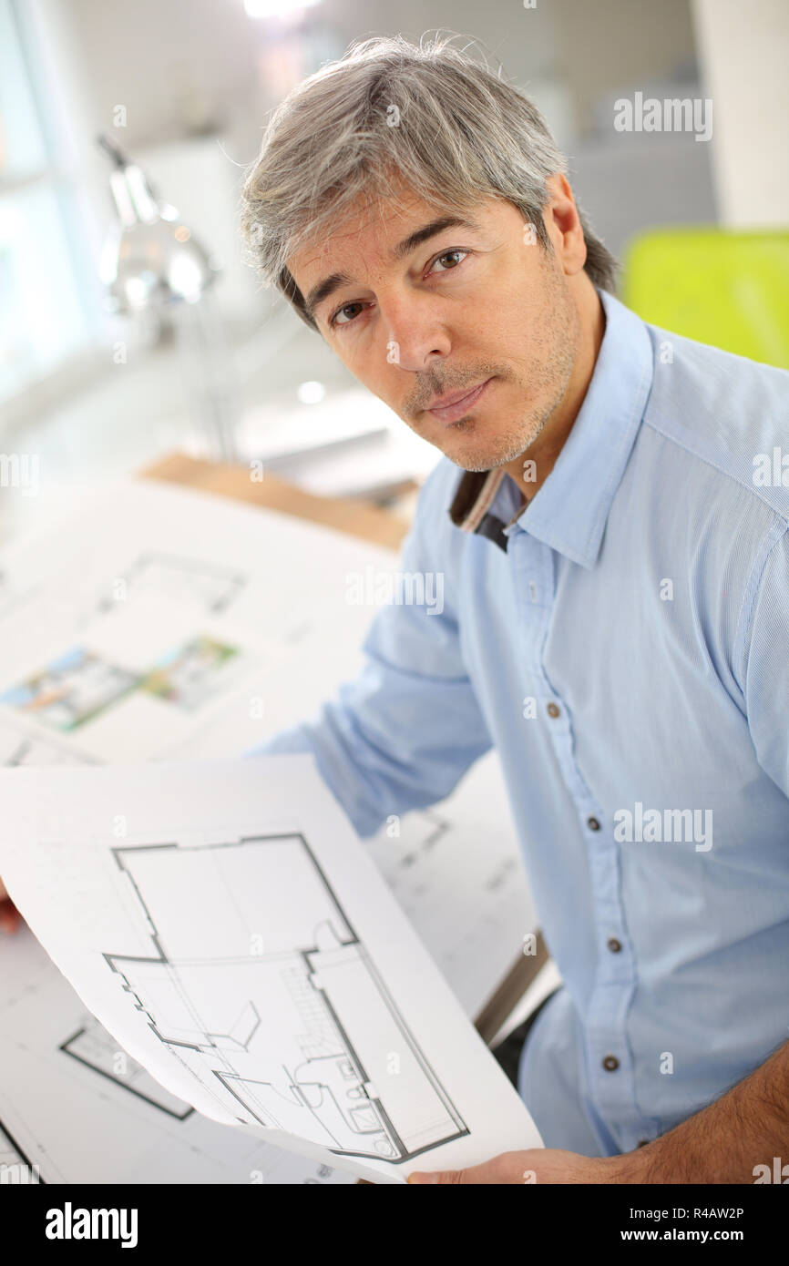 Architect working on blueprint in office Stock Photo - Alamy