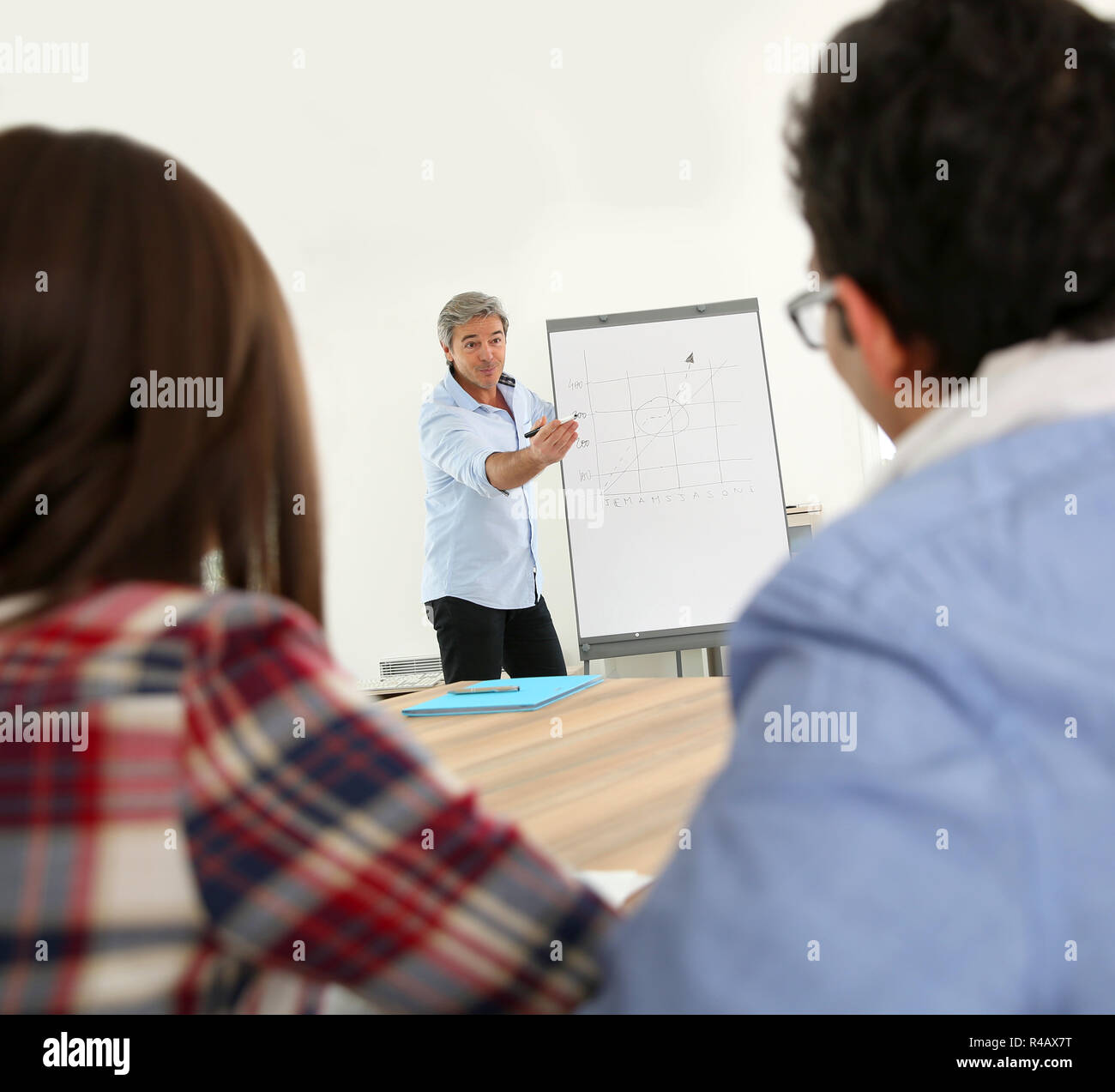 Teacher in business class doing marketing presentation Stock Photo - Alamy