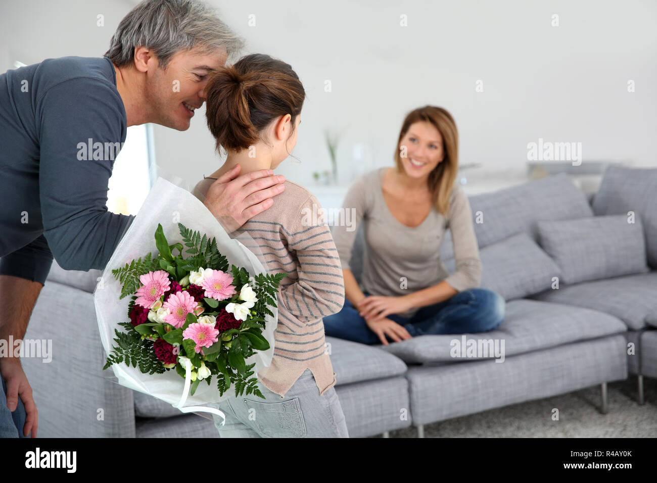 Young girl offering flowers to her mom Stock Photo - Alamy