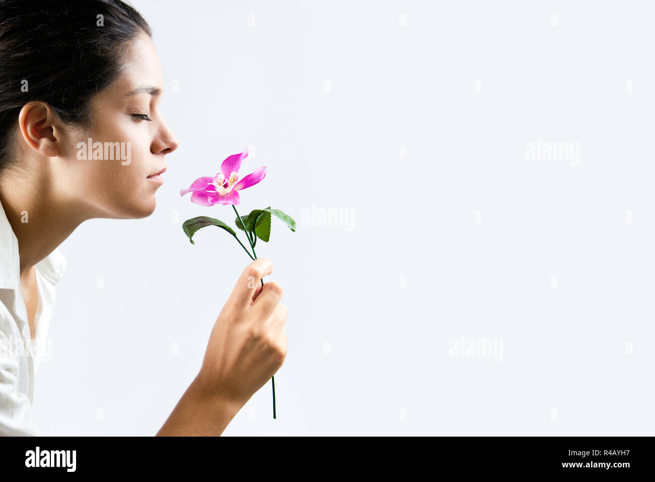 Profile photo of a beautiful girl smelling a flower Stock Photo - Alamy