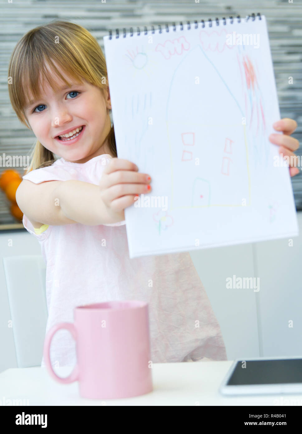 Child drawing with crayons, sitting at table in kitchen at home Stock ...