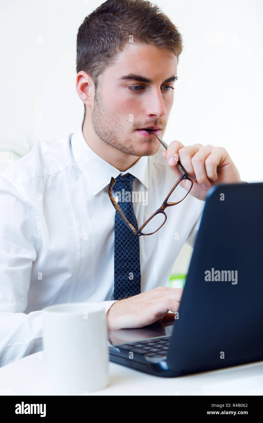 Young handsome man working in his office with laptop Stock Photo - Alamy