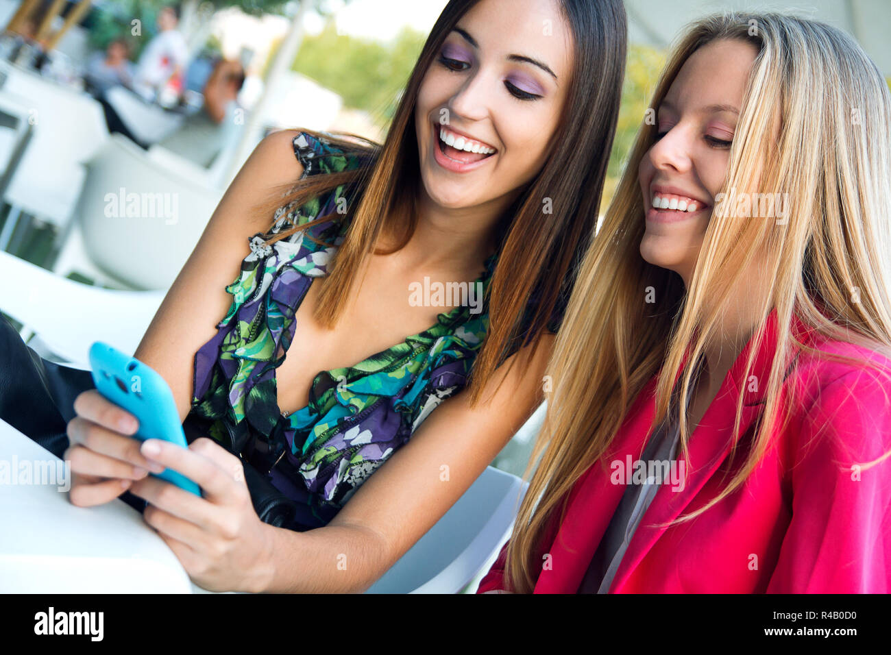 Two friends having fun with smartphones Stock Photo - Alamy