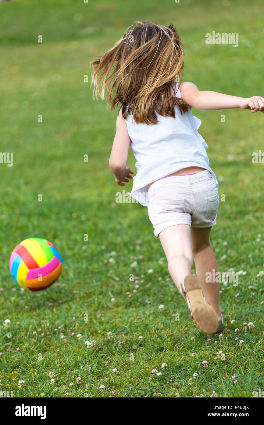 happy little girl playing ball in the park Stock Photo - Alamy