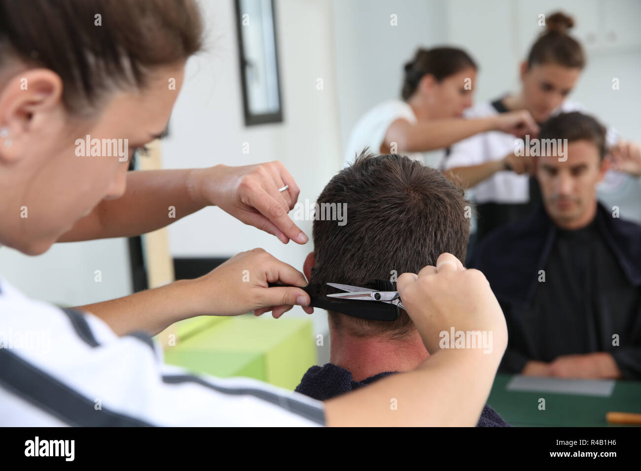 Student girl in hairdressing learning how to cut hair Stock Photo - Alamy