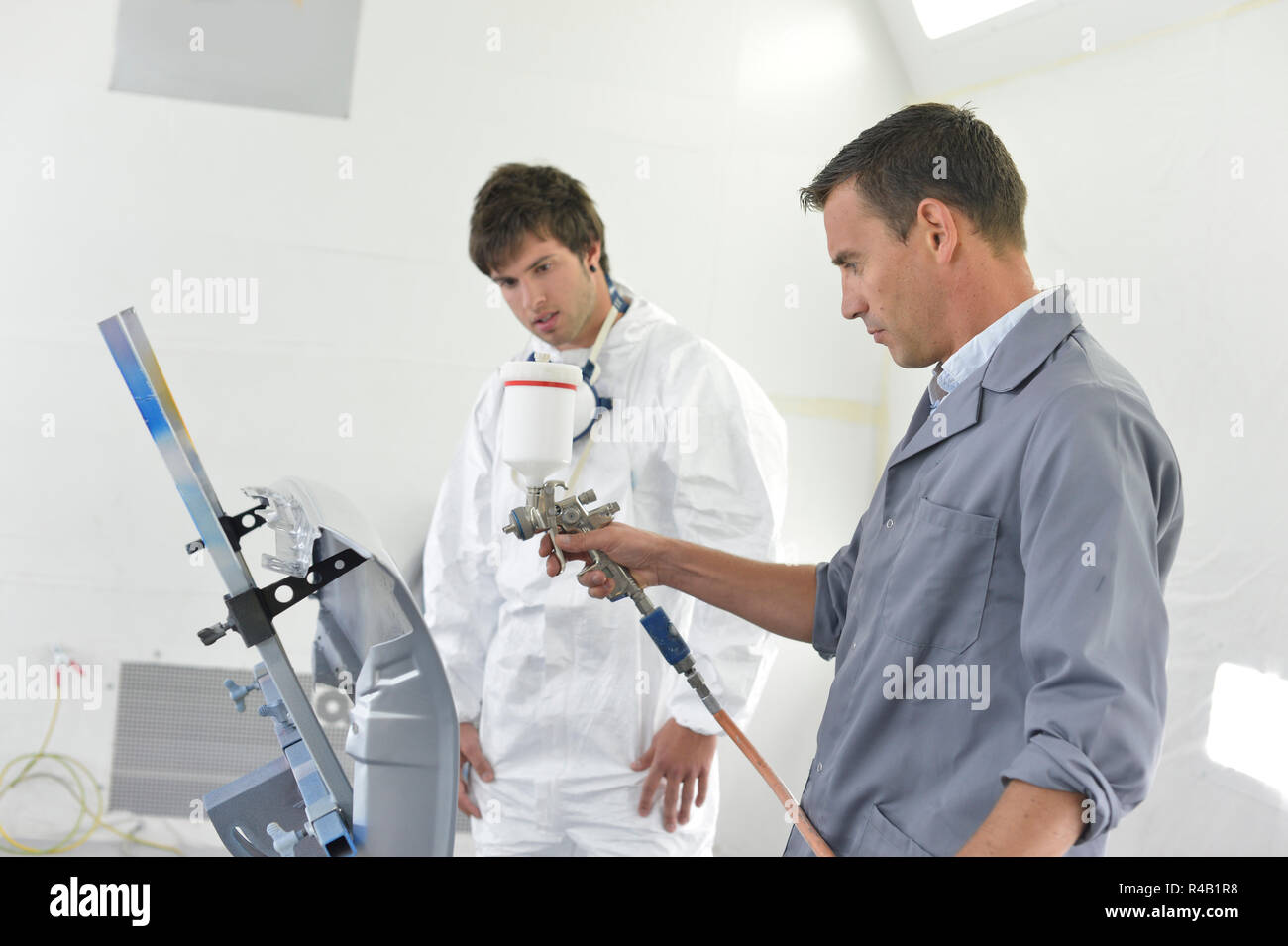 Instructor with teenager in car painting training class Stock Photo - Alamy