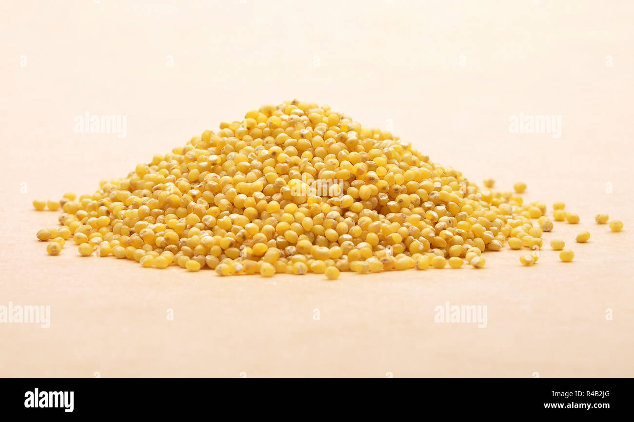 Raw millet on brown background Stock Photo - Alamy