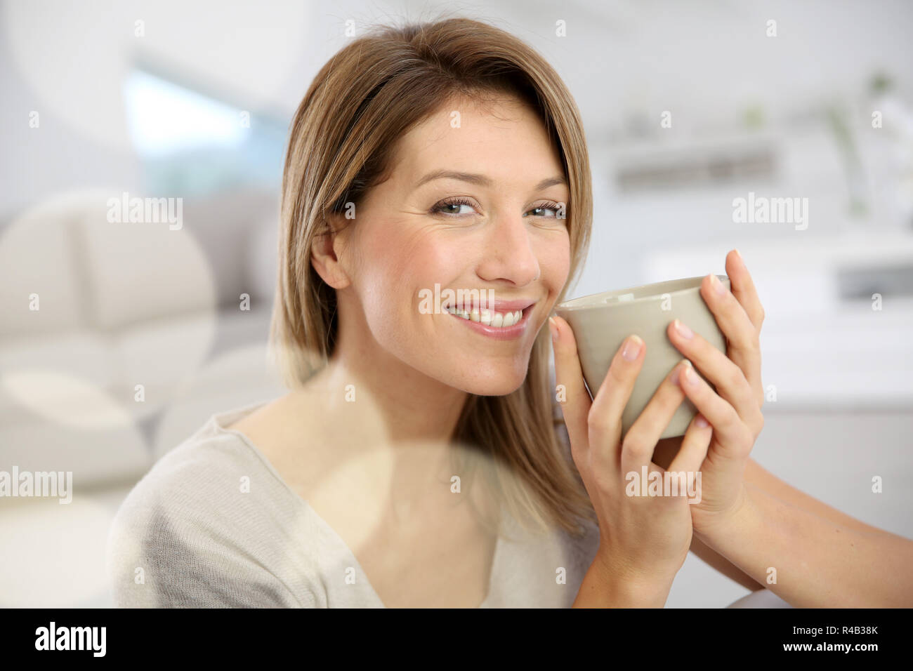 Beautiful woman drinking hot tea Stock Photo - Alamy
