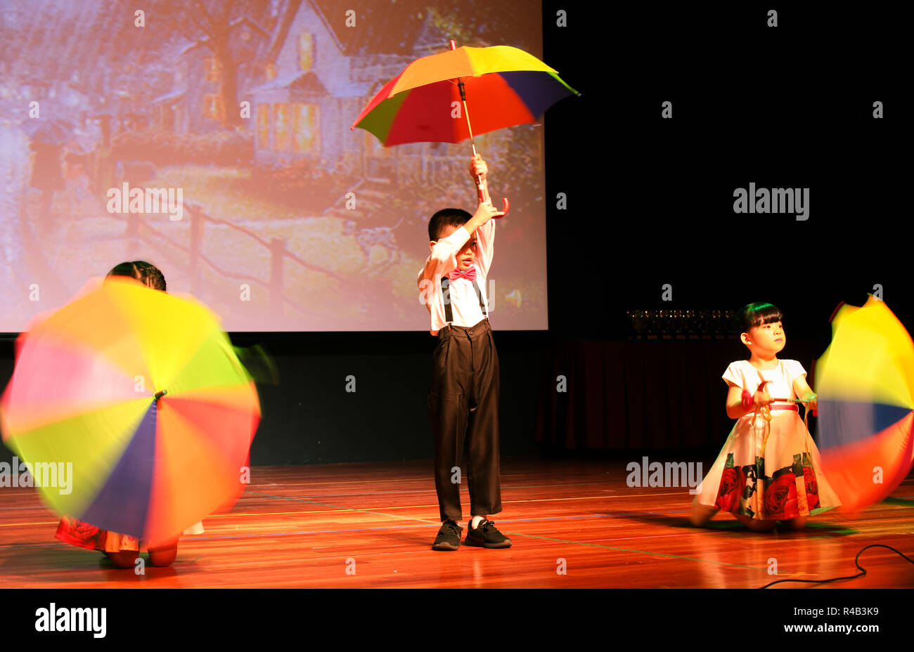 Children performing umbrella dance on stage during their kindergarten ...