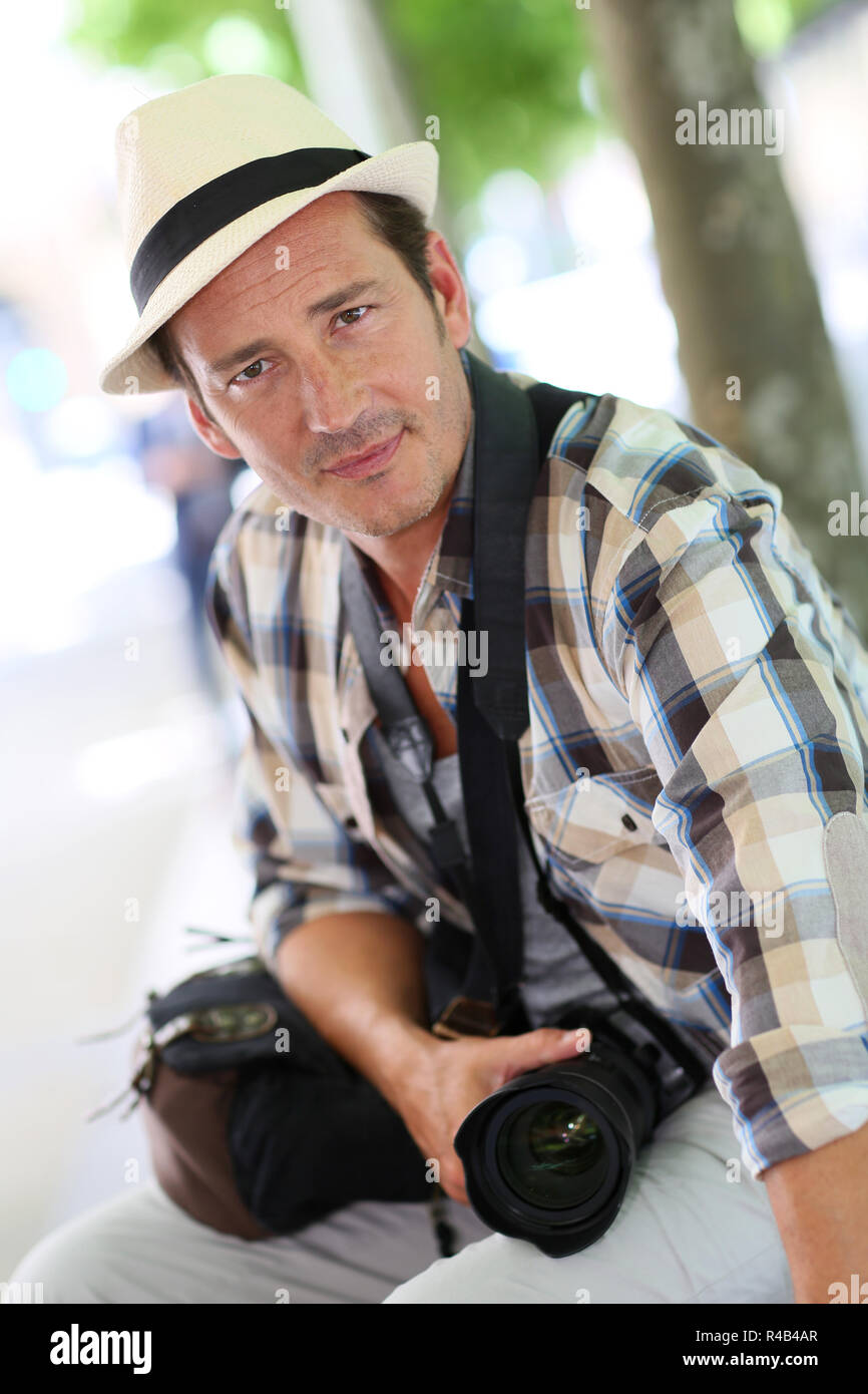 Portrait of smiling photo reporter walking in town Stock Photo - Alamy
