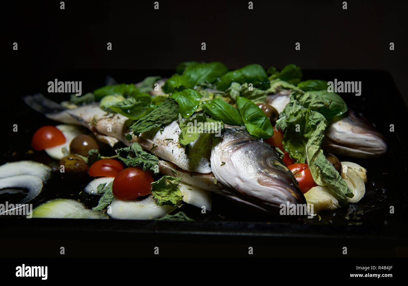 Fresh sea bas fish ready to cook, fresh fish prepared to grill covered ...