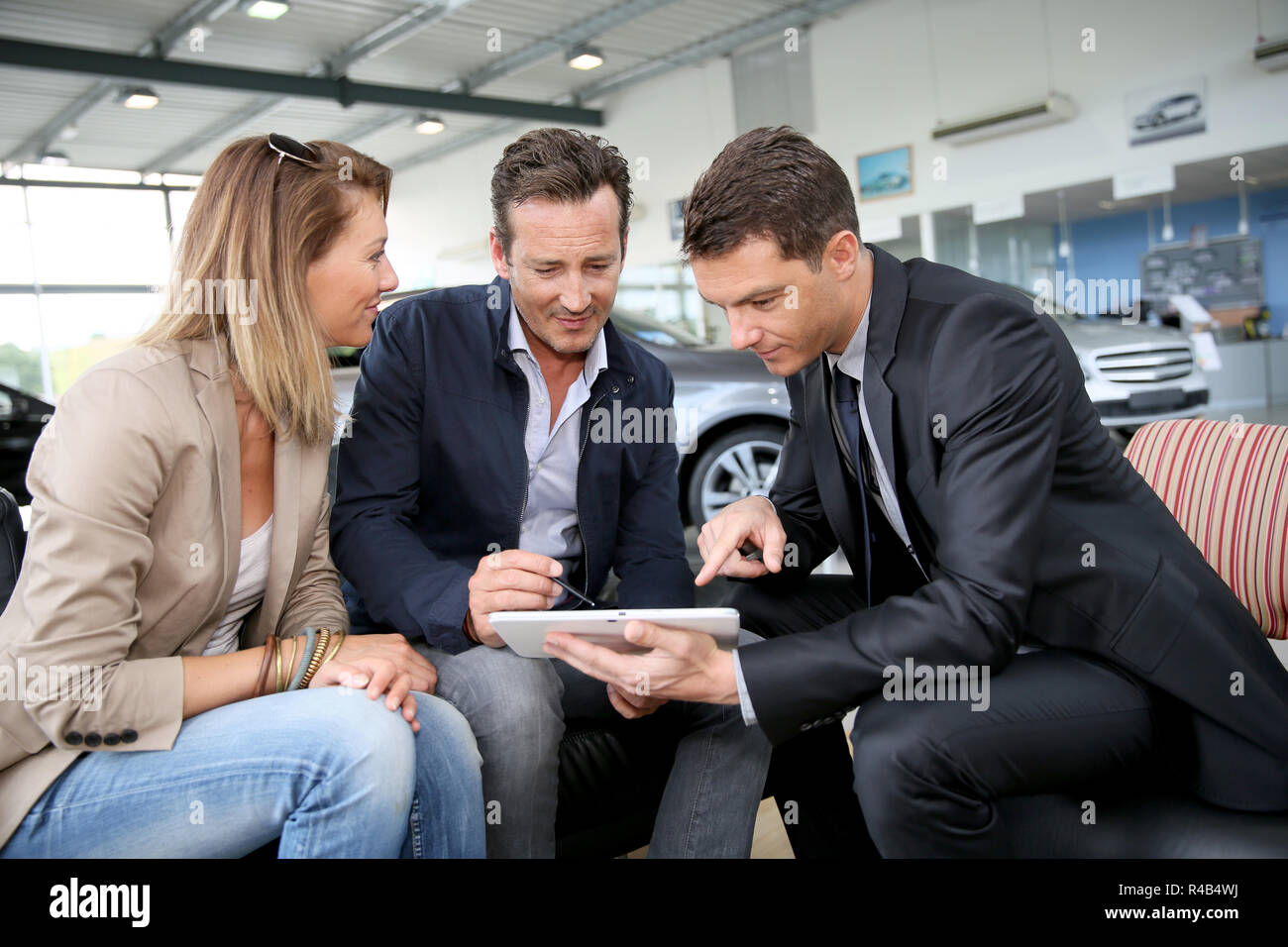 Couple signing car purchase order on digital tablet Stock Photo - Alamy