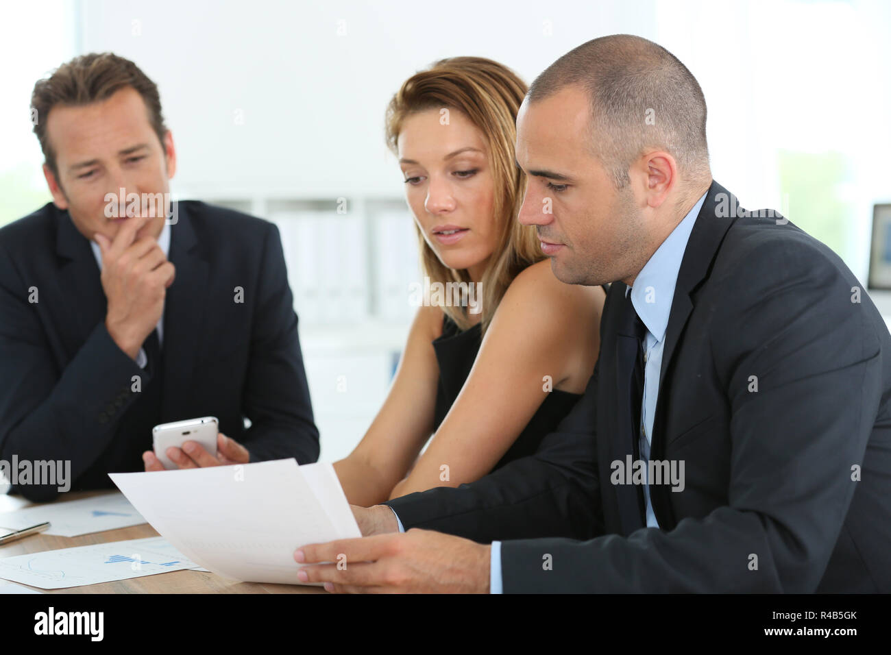 Business people looking at budget forecast Stock Photo - Alamy