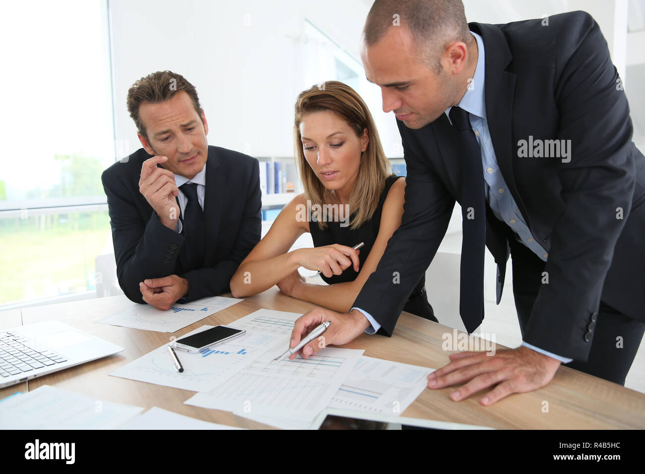 Business people looking at budget forecast Stock Photo - Alamy