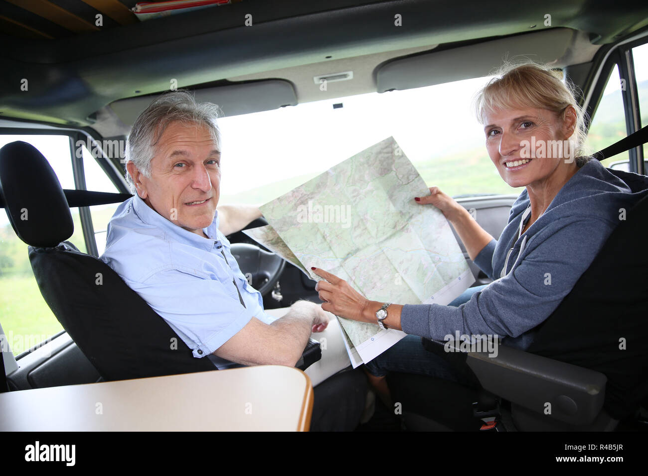 Senior couple riding camper and reading road map Stock Photo - Alamy