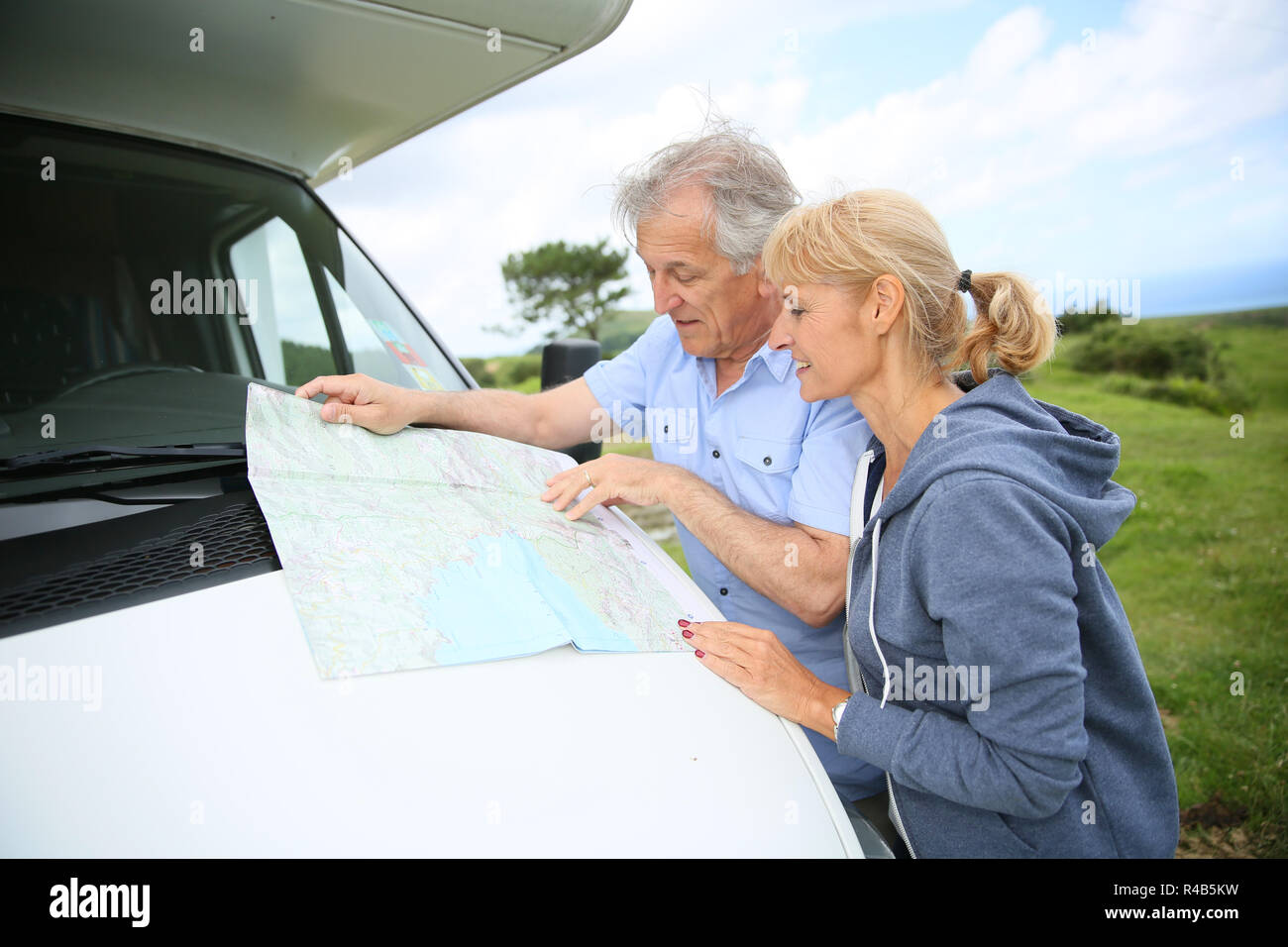 Senior people reading road map by camper Stock Photo - Alamy