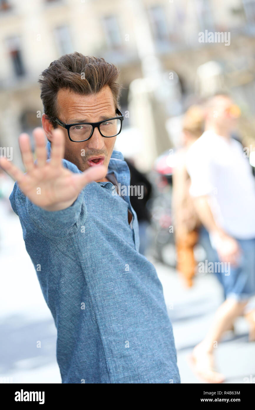 Cheerful guy with eyeglasses pointing at camera Stock Photo - Alamy