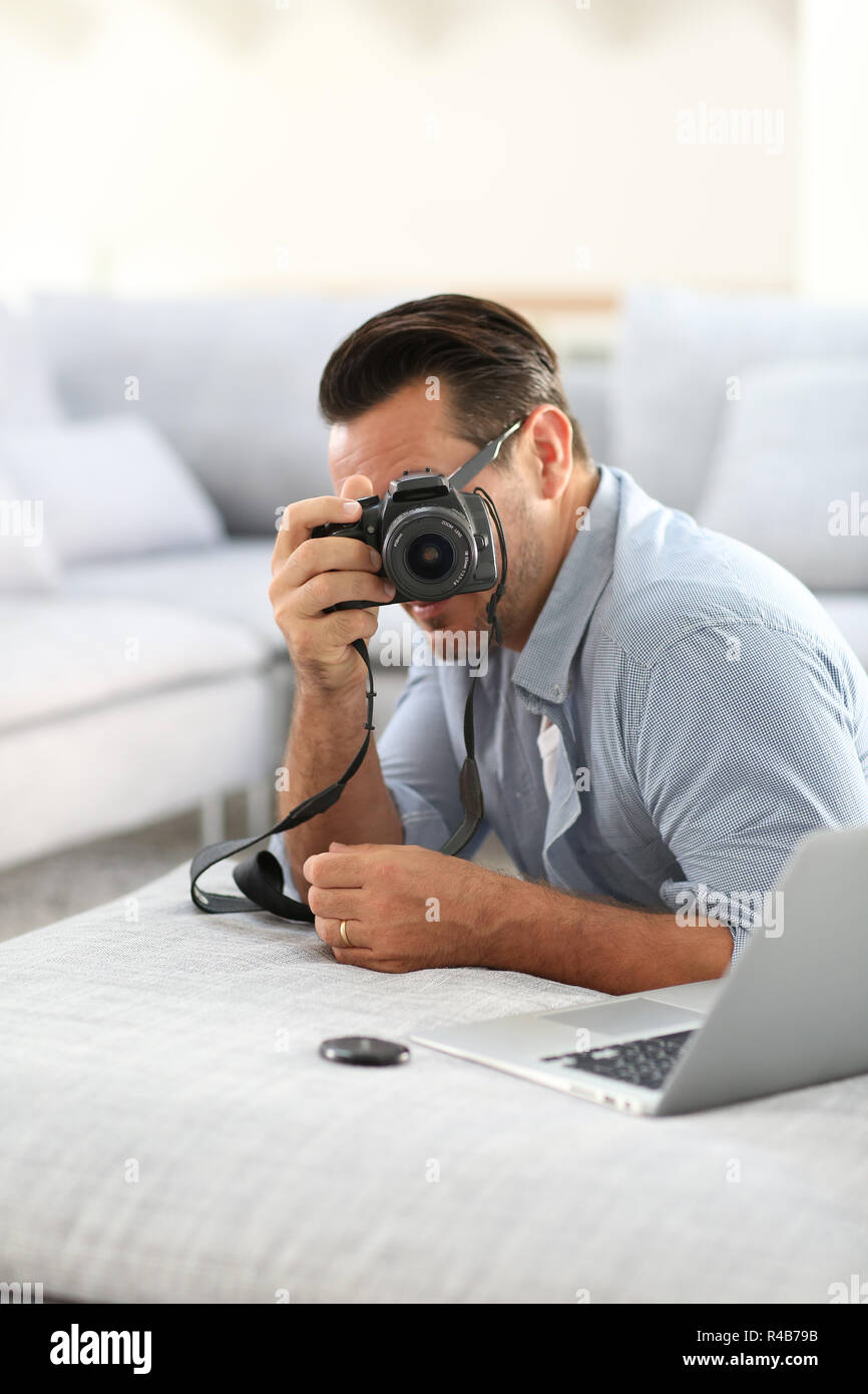 Man at home using digital camera and laptop Stock Photo - Alamy